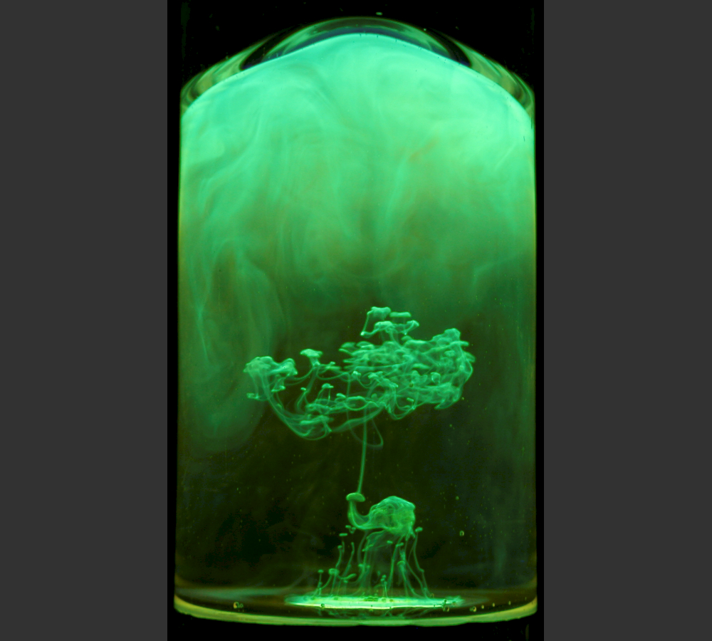 An upside-down image of green highlighter dropped into water, showing ...