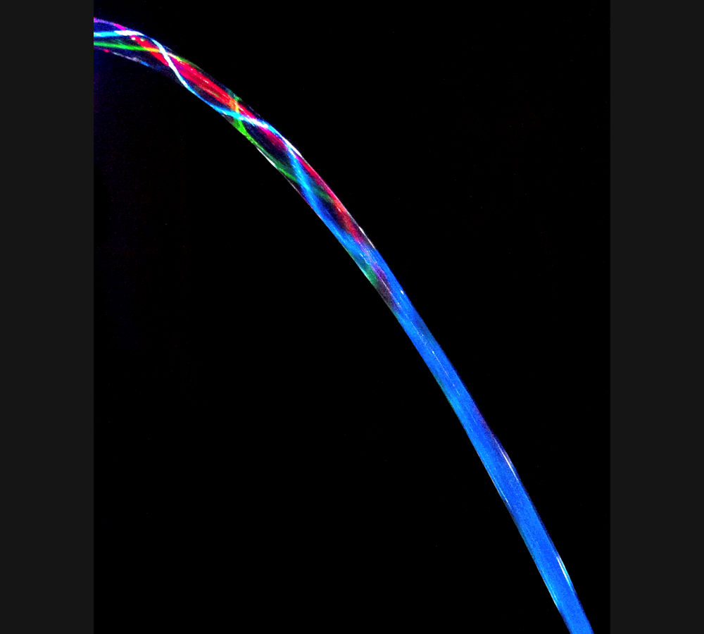 Total internal reflection in a water stream traps three lasers. - Flow Visualization