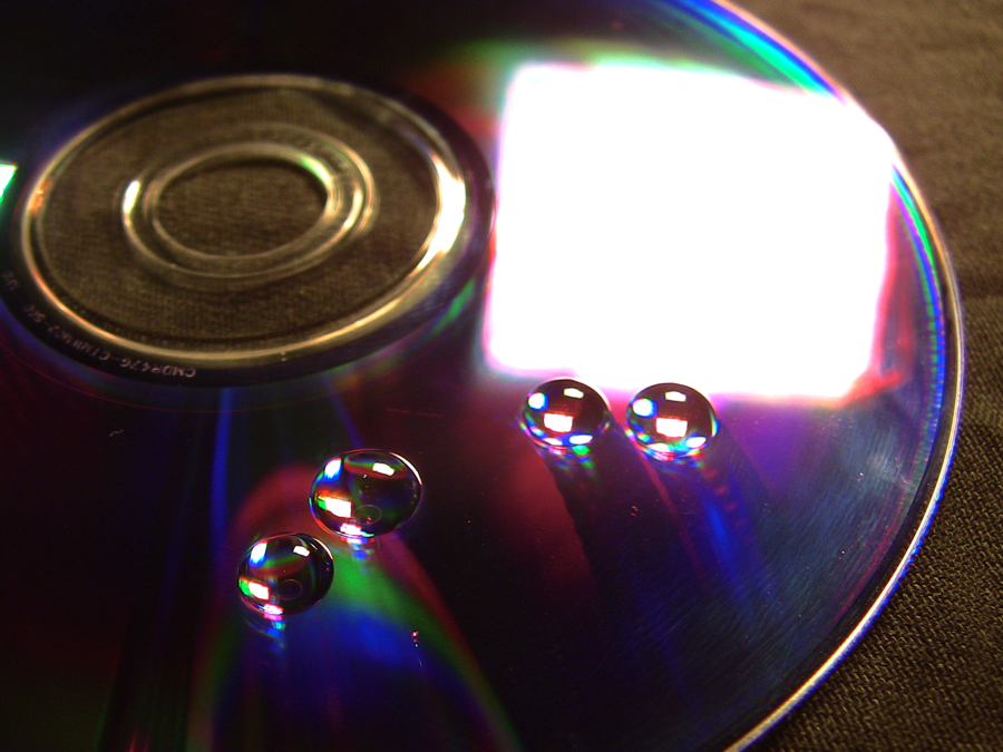 Droplets of glycerin on a CD reflect and refract light while the CD ...