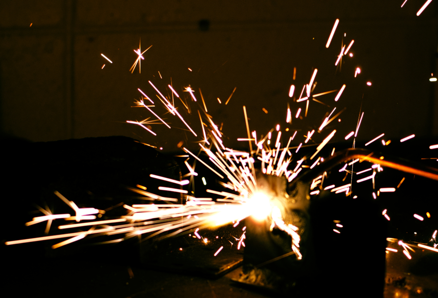 Sparks scatter as an oxy-acetylene torch burns through a plate of steel ...