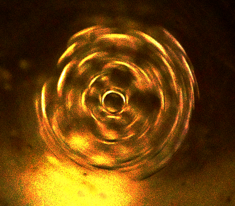 Air bubbles rotate in a beaker of spinning water. - Flow Visualization