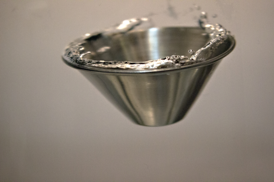 Air is trapped in the wake of a steel cup as it falls through water ...