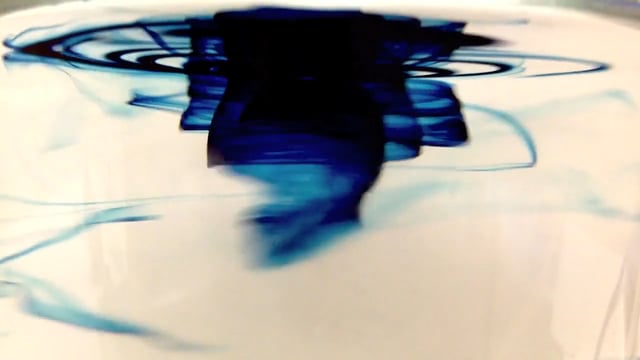 Heavy food dye dropped gently into a water vortex and viewed from the ...