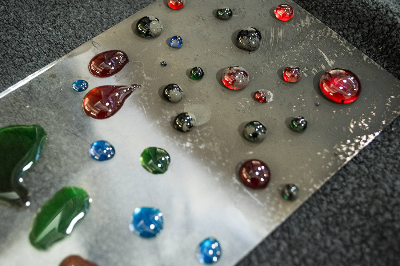 Colored water droplets on a glass surface made superhydrophobic by condensed soot. David Leng ...